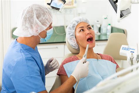 보호 마스크의 자격을 갖춘 남성 치과 의사가 장치를 사용하여 여성 환자를 검사 할 것입니다 30 34세에 대한 스톡 사진 및 기타 이미지 Istock