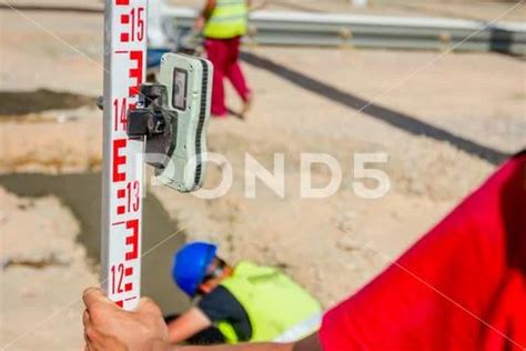 Photograph Worker Is Holding Leveling Rod To Measuring Level On Construction Site 90445617