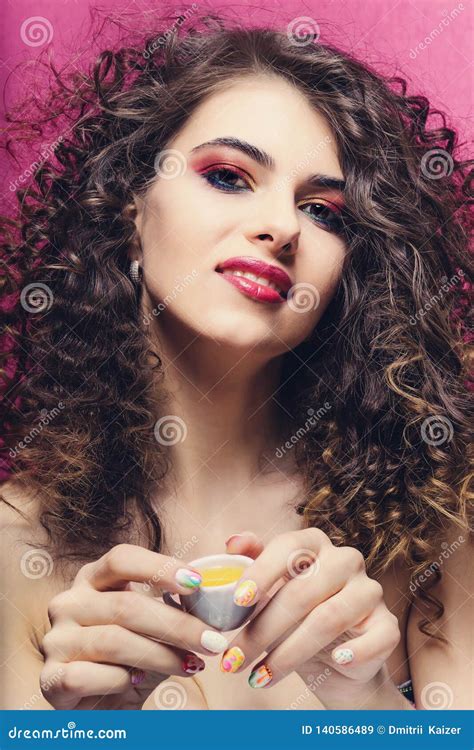 Bella Ragazza Riccia Con Il Sorriso Colourful Del Manicure E Bevanda Da