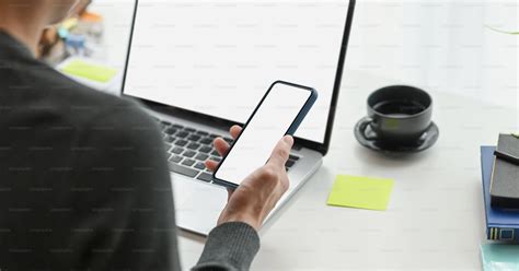 휴대 전화를 사용하고 현대 직장에서 컴퓨터 노트북으로 작업하는 청년 프리랜서의 어깨 너머로 볼 수 있습니다 사진 Unsplash의 노트북 사용 이미지