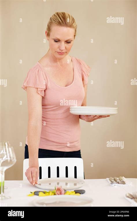 Perfect Place Settings A Beautiful Woman Setting The Table At Home Stock Photo Alamy