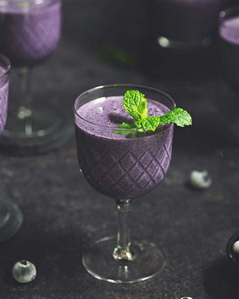 잔에 민트 장식을 곁들인 보라색 음료 사진 Unsplash의 무료 유제품 이미지