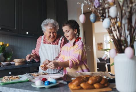 Grandmother With Grandaughter Preparing Traditional Easter Meals Baking Cakes And Sweets