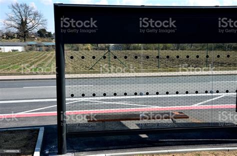 시내 버스 정류장 통합 된 나무 벤치가있는 유리 쉼터 지붕과 뒷벽 만 도시의 보도 옆 거리에 우아한 아치 역 플랫폼 잔디 잔디 촉각 갈색에 대한 스톡 사진 및 기타 이미지