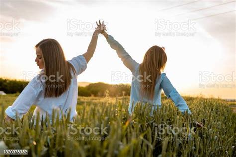 밀밭에 서 있는 두 명의 청녀 그들은 밀밭 한가운데 서 팔을 들고 손을 들고 서 있었다 2명에 대한 스톡 사진 및 기타 이미지 2명 계절 고요한 장면 Istock