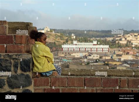 Young Eritrean Girl Sitting On A Wall Overlooking The City Of Asmara