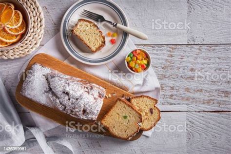 테이블에 수건과 포크가 달린 나무 판에 누워 말린 오렌지와 함께 조각으로 자른 가루 설탕을 곁들인 흰색 달콤한 빵 0명에 대한 스톡 사진 및 기타 이미지 Istock