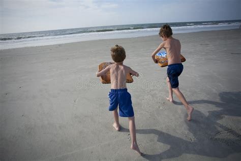 пристаньте мальчиков к берегу молодых Стоковое Фото изображение насчитывающей каникула бежать