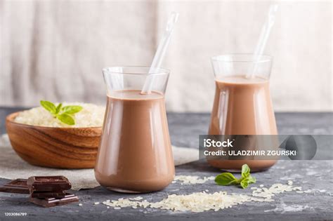 검은 콘크리트 배경에 쌀 씨앗과 유리와 나무 접시에 유기 비 유제품 쌀 초콜릿 우유 비건 건강 식품 개념 클로즈업 사이드 뷰 카피 공간 0명에 대한 스톡 사진 및 기타