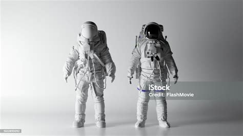 하얀 우주복을 입은 두 명의 우주비행사가 하얀 배경에 서 있다 조명이 바뀌고 있습니다 흑백 헬멧 우주 비행사에 대한 스톡 사진 및 기타 이미지 Istock