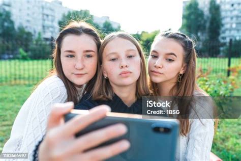 세 여자 여학생 1315 세 도시에서 가을 여름 날 전화에 자신의 사진을 찍고 행복 미소 캐주얼 옷 방과 후 휴식 온라인 소셜