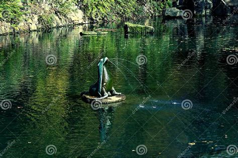 A Statue Is The Focal Point Of This Image With Water Spraying From Its