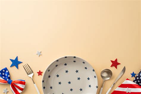 독립 기념일 축하를 위한 축제 설정 접시 수저 반짝이는 별 넥타이 나비 넥타이가 있는 테이블 세트의 평면도는 베이지색 배경에 텍스트 또는 광고를 위한 공간이 있습니다 0명에