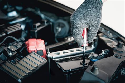 닫기 남자 착용 장갑 사용 드라이버 는 증류를 추가하기 위해 캡 배터리를 엽니 다 자동차의 연장 된 서비스 수명 배터리에 대한