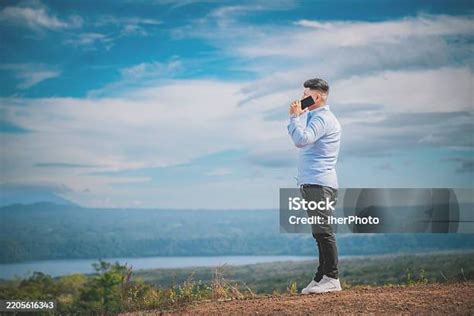자연에 둘러싸인 야외에서 전화 통화를 하는 잘생긴 청년 아름다운 경치 좋은 전망에서 전화 통화하는 사람 30 34세에 대한 스톡