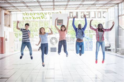青少年多种族群体在学校院子里跳跃幸福自由运动多样和人的概念高清图片下载 正版图片503506175 摄图网