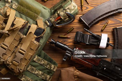 군용 방탄복 헬멧 및 탄약 Matrons와 응급 처치 지혈대가있는 Kalashnikov 돌격 소총 검은 대리석 테이블에 육군 방탄 조끼 플랫 레이 군사 개념입니다 군사에
