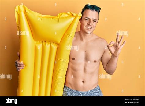 Handsome Young Man Wearing Swimsuit And Holding Summer Float Doing Ok