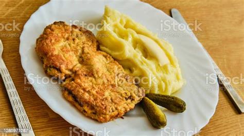 포크와 칼이 있는 나무 테이블에 으깬 감자를 곁들인 로스트 소고기 슈니첼 내부의 맛있는 맛 0명에 대한 스톡 사진 및 기타