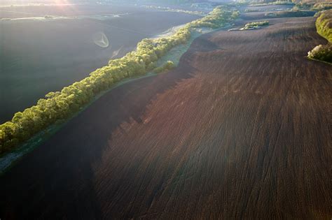 봄에 녹색 숲 사이에 작물을 심기 위해 준비 된 재배 비옥한 토양으로 쟁기 농경지의 공중 보기 공중 뷰에 대한 스톡 사진 및 기타 이미지 Istock