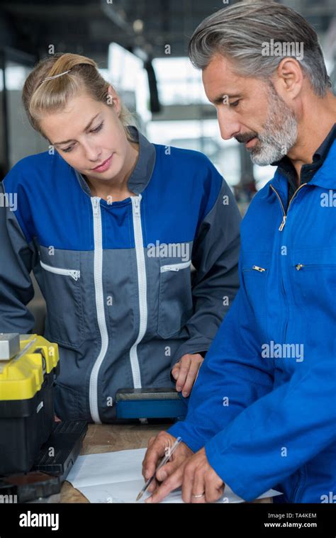 Male And Female Engineers Looking At Paperwork Stock Photo Alamy