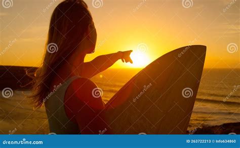 Lens Flare Carefree Surfer Girl Pointing Towards The Breathtaking