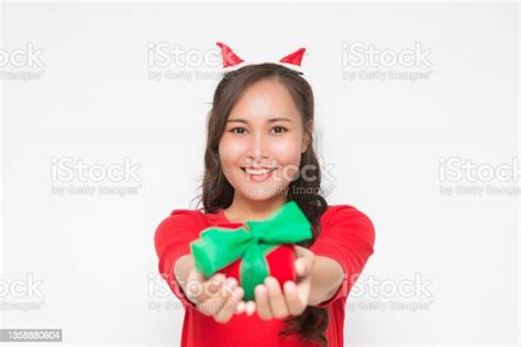 작은 산타 모자를 쓰고 흰색 배경에 빨간 선물 상자를 들고 빨간 드레스를 입은 아름다운 아시아 여성 12월 31일에 대한 스톡 사진 및 기타 이미지 Istock