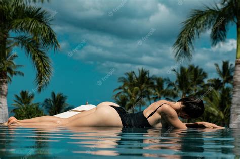 Premium Photo Sexy Woman Sunbathing In Infinity Swimming Pool At