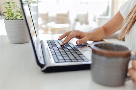 손 노트북 및 원격 근무는 프리랜서 또는 스타트업 비즈니스를 위해 홈 오피스에 있는 사람과 함께 합니다 컴퓨터 키보드 및 행정 이메일 또는 연구 근접 촬영을 위해 아파트에서