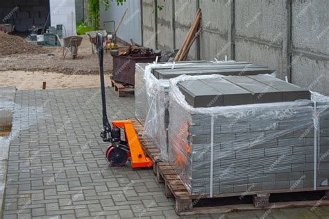 오래 된 오렌지 수동 핸드 팔레트 트럭 유압 핸드 팔레트 트럭의 바퀴를 닫습니다 프리미엄 사진