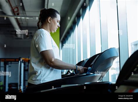 Adult Plus Size Woman Run On Treadmill At Fitness Gym Side View