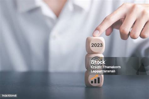 2023년 새해 시작 개념 비즈니스 성장 그래프 및 성공 목표 개발 진행 상황 재무 효율성 및 투자 테이블에 놓인 나무 블록을 가리키는 인간의 손 개발에 대한 스톡 사진 및