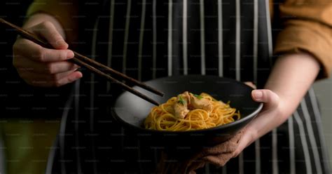 Schezwan 국수 또는 차우멘 그릇과 젓가락을 들고 있는 여성의 모습을 클로즈업합니다 사진 Unsplash의 태국 이미지