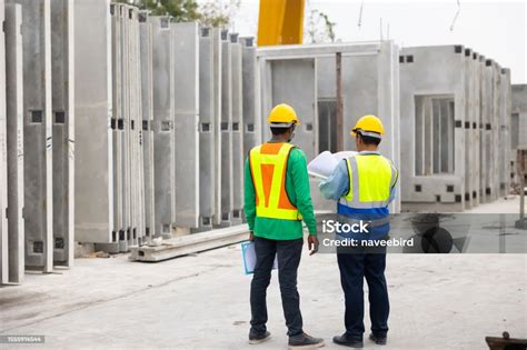 뒤 Viewconstruction 청사진 종이 아시아계 인도 건설 건축가 엔지니어링 남자와 안전 안전모의 선임 노동자는 조립식 콘크리트 공장에서 청사진 작업을 하고 있다