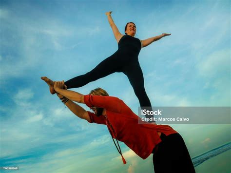 젊은 매력적이 고 아름 다운 곡예 사 커플 휴식과 명상 개념과 건강 한 라이프 스타일에 해변에서 요가를 실천 하는 Acroyoga 운동 집중 된 유지 균형 2명에 대한 스톡