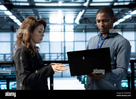 Data Center Programmer And Colleague Using Laptop Conducting Security