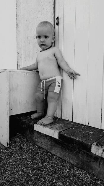 Premium Photo Portrait Of Shirtless Boy Standing Against Door
