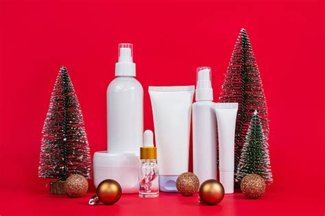 밤 데이 크림 화장품 오일 크리스마스 공 나무와 빨간색 배경에 아이 크림과 공간을 복사합니다 선물 모형 스타일의 브랜드가 없는 병 뷰티 배경 겨울에 대한 스톡 사진 및 기타