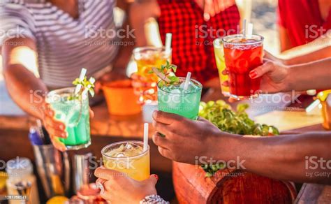 모히토와 재미를 응원 하는 행복 한 사람들 코로나 바이러스로부터 보호 할 수있는 얼굴 마스크와 함께 여름철 바 밖의 해변 바에서