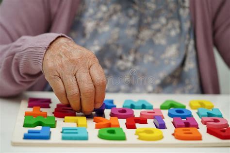 Asian Elderly Woman Playing Puzzles Game To Practice Brain Training For Dementia Prevention