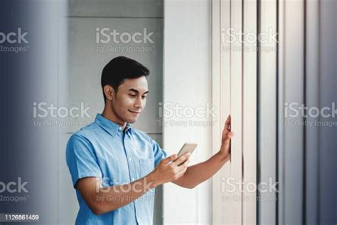 행복 한 사업가 사용 하 여 스마트폰 사무실에서 창에 의해 서 휴대 전화를 통해 메시지를 읽고 웃 고 긍정적인 감정 표현에 대한 스톡 사진 및 기타 이미지 Istock