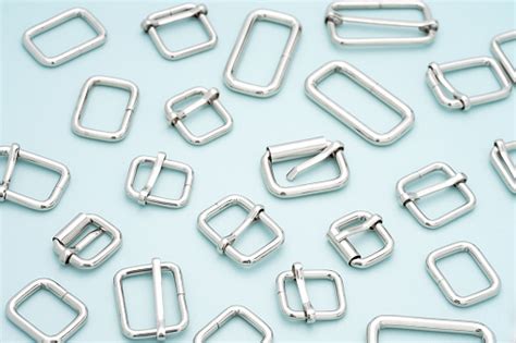 연한 파란색 배경에 가방과 배낭을 만들기위한 금속 조절기 및 프레임 핸드백 스트랩을위한 크롬 도금 금속 프레임 바느질 액세서리 가방 만들기 0명에 대한 스톡 사진 및 기타