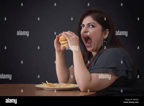 Angry Irritated Fat Woman Eating A Hamburger Stock Photo Alamy