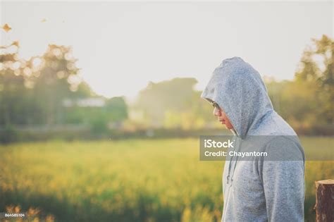 후드와 함께 재킷을 착용 하 고 아침에 햇빛 풀밭에 서 있는 남자 겨울에 대한 스톡 사진 및 기타 이미지 겨울 겨울 코트 농업 Istock