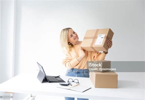 높이 조절 가능한 테이블에 서서 주문했거나 곧 배송하려고하는 다양한 소포를보고있는 예쁜 젊은 여성 40 44세에 대한 스톡 사진 및 기타 이미지 Istock