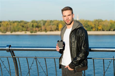 목가적인 아침 힙스터는 종이 커피 컵을 들고 있다 커피 휴식 이동 중에서 마셔 남자 힙스터 는 강변 배경을 멀리 커피를 들고 잘생긴 사람은 야외에서 커피를 마십니다 의식은