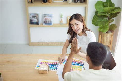 Couple Select Sample Color In Palette Wheel With Concept Of Interior Exterior Paint Stock Image