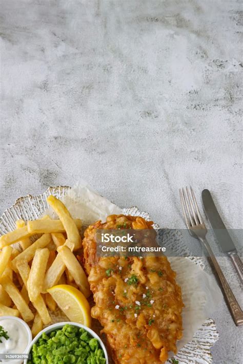 레몬 슬라이스 타르타르 소스 부드러운 완두콩 나이프와 포크 대리석 효과 배경 높은 보기 복사 공간과 함께 제공되는 기름칠 양피지가 있는 불규칙한 테두리가 있는 흰색 금색