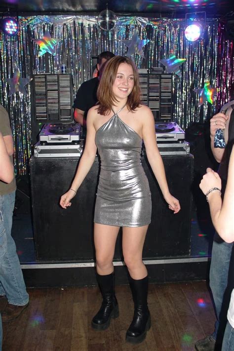 Woman In A Typical 2000s Club Wearing A Metallic Halter Dress With