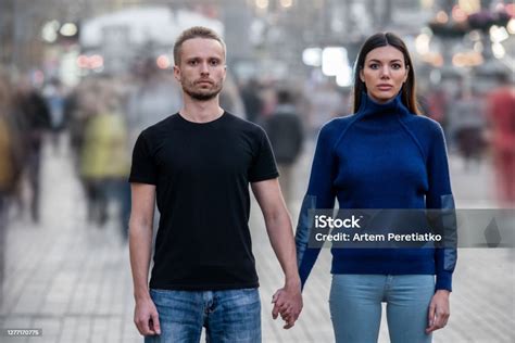 젊은 남자와 여자는 거리의 중간에 서서 손을 잡고 25 29세에 대한 스톡 사진 및 기타 이미지 25 29세 2명 30